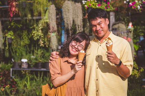 야외 공원에서 아이스크림 콘을 먹고 즐기는 젊은 미소 아시아 커플의 초상화 정원에서 함께 시간을 보내고 커플 사람과 라이프 스타일 개념 2명에 대한 스톡 사진 및 기타