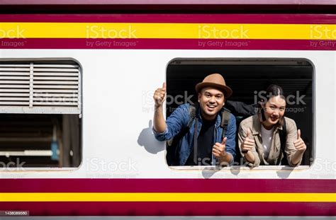 신혼 여행에 가방을 가진 커플 아시아 여행자 기차로 여행 창문 밖으로 머리를 찌르십시오 플랫폼 기차역 근처의 행복한 남자와 여자 휴가 시간 휴일 주말에 관광 계획 2명에