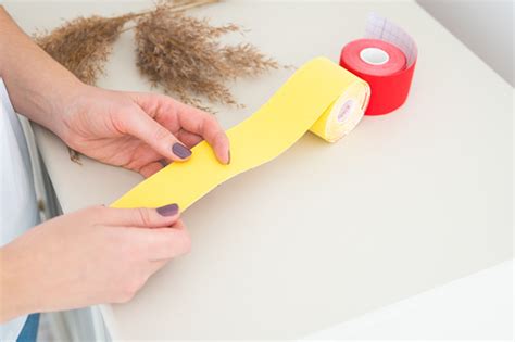 얼굴 주름에 대한 Kinesio 테이프가있는 여성 손 여자는 얼굴의 피부를 들어 올리기위한 테이프를 손에 쥐고 있습니다 건강관리와 의술에 대한 스톡 사진 및 기타 이미지