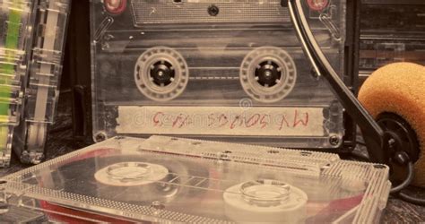 Stack Of Cassettes And Spinning In Player Cassette And Player Stock