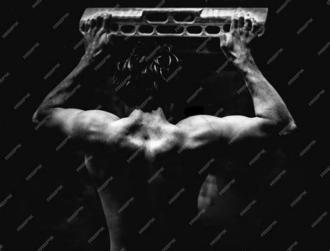 Premium Photo Rear View Of Shirtless Man Lifting Heavy Object Against