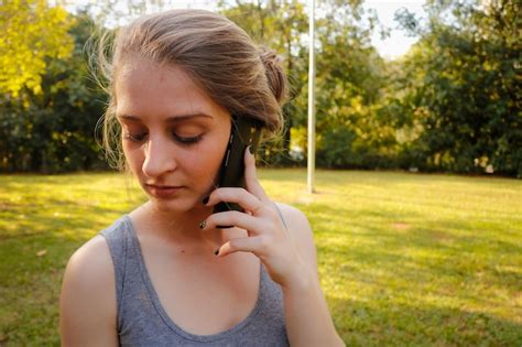 Premium Photo Young Woman Using Mobile Phone At Park
