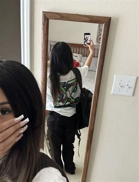 A Woman Taking A Selfie In Front Of A Mirror With Her Hand On Her Face