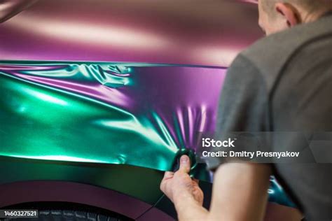 작업 과정에서 카멜레온 색 비닐 필름으로 자동차를 포장하는 전문가 자동차 포장 전문가는 비닐 시트 또는 필름으로 자동차를 덮습니다 숄에 대한 스톡 사진 및 기타 이미지