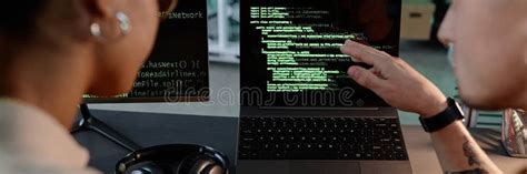 Header Image Of Male And Female Developers Discussing Code On Laptop Screen In Office Stock