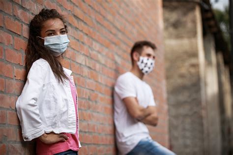 도시 거리에서 버스를 기다리는 두 명의 젊은이와 사회적 거리를 유지 20 29세에 대한 스톡 사진 및 기타 이미지 20 29