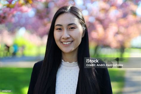 A Happy Japanese Woman Smiles In A Professional Portrait Exuding