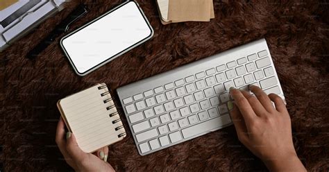 무선 키보드로 타이핑하고 갈색 모피 깔개 위에 노트북을 들고 있는 여성의 모습 사진 Unsplash의 휴대폰 이미지