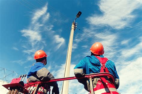 두 명의 전기 기술자가 가로등을 올려다봅니다 문제 해결 및 정전 가로등에 대한 스톡 사진 및 기타 이미지 가로등 수리