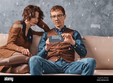 Man Shows To His Wife How To Control Their Smart Home From Smartphone Stock Photo Alamy