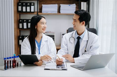 의료 기술 네트워크 팀 회의 개념입니다 아시아 의사는 스마트 폰 현대 디지털 태블릿 및 그래픽 차트 인터페이스가있는 노트북 컴퓨터로 작업합니다 25 29세에 대한 스톡 사진