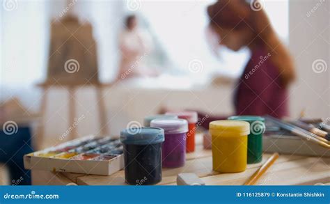 Paints And Art Supplies In Front Of Artists Performing Artistic Etude Witn Naked Model Stock