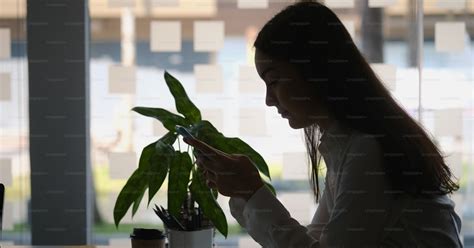 사무실에 앉아 스마트폰을 사용하는 아름다운 사업가의 실루엣 사진 Unsplash의 무선 기술 이미지