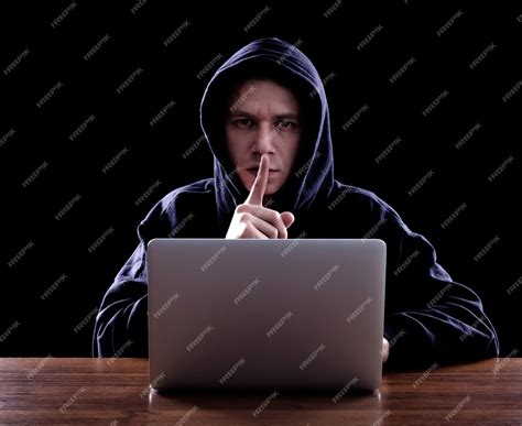 Premium Photo Hooded Computer Hacker Stealing Information With Laptop