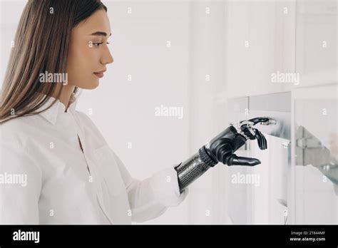 Focused Woman Using A Sophisticated Bionic Hand To Interact With A