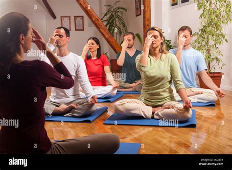 Young People Practising Yogic Breathing Technique Called Pranayama
