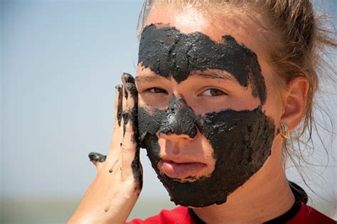 그녀의 얼굴에 진흙 마스크를 가진 젊은 아름다운 소녀 소녀는 여드름 그녀의 얼굴에 진흙 마스크로 고통받습니다 스킨 케어 블루 점토 건강관리와 의술에 대한 스톡 사진 및 기타