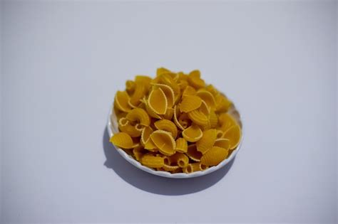 Premium Photo Raw Macaroni On A Small White Plate With A White Background