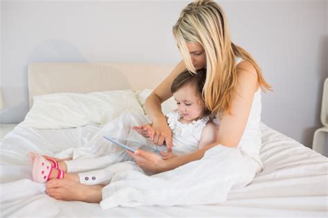 Madre E Hija Usando Tableta Digital En La Cama Foto Premium