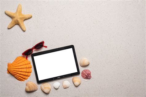 여름 해변 휴가 컨셉으로 자유로운 텍스트 공간을 즐길 수 있다 평면도 선글라스와 빈 태블릿 큰 불가사리와 주황색 가리비 껍질 및 기타 작은 껍질이 고운 모래 배경에 함께