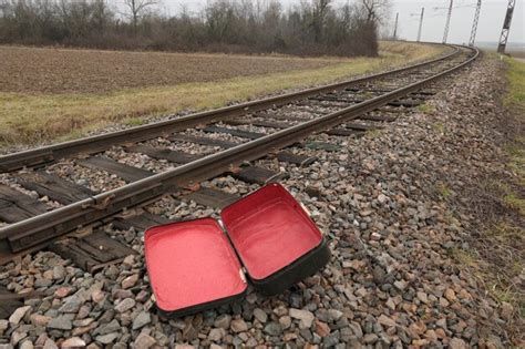 Premium Photo Empty Suitcase On Rocks By Railroad Track