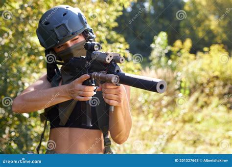 Beautiful Female In Camouflage In Her Arms During A War Is Aiming At A Target Or An Enemy In