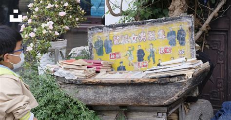 Foto Un Hombre Sentado En Una Silla Junto A Una Mesa Con Un Letrero