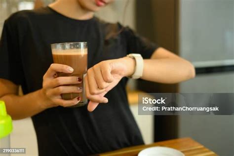 초콜릿 단백질 쉐이크 한 잔을 들고 스마트워치를 확인하는 젊은 남자 20 24세에 대한 스톡 사진 및 기타 이미지 20 24