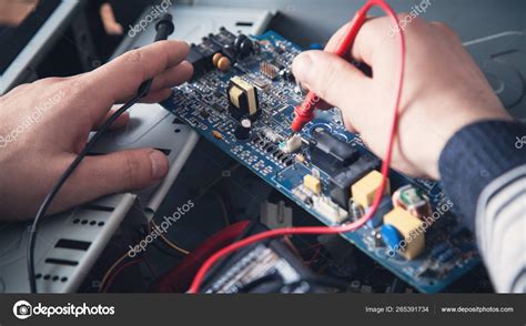 Man Checking Computer With A Multimeter Stock Photo ANDRANIK