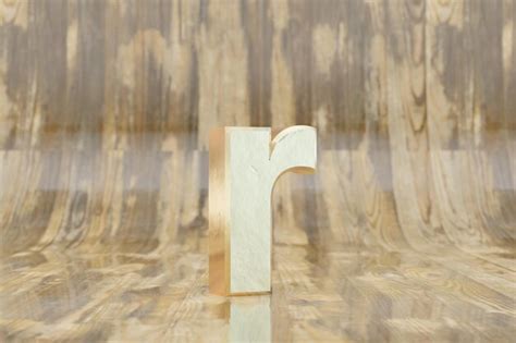 골드 3d 문자 R 소문자입니다 광택 젖은 나무 배경에 황금 편지입니다 결함이 있는 황금 알파벳입니다 3d 렌더링된 글꼴 문자입니다 프리미엄 사진