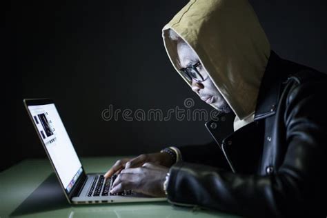 Afro American Hacker In Hood Using Laptop Computer In The Dark Hack Networks Or Emails Account