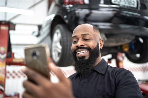 자동차 수리에 자신의 스마트 폰으로 화상 통화를 하는 정비사 남자 자동차 정비공에 대한 스톡 사진 및 기타 이미지 자동차 정비공 전화 자동차 수리 공장 Istock