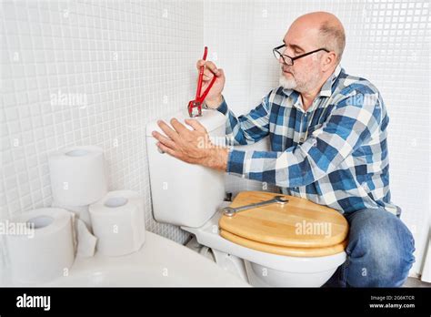 Craftsman Or Do It Yourselfer With Pipe Wrench Repairs The Cistern In The Toilet Stock Photo Alamy