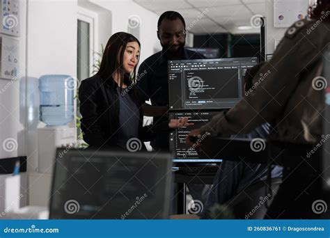 Multi Ethnic Programmers Checking Source Code And Database Stock Image