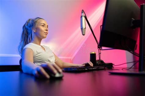 Focused Professional Gamer Girl Streams And Play Online Multiplayer Video Game On Pc Stock Photo