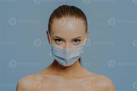 Studio Shot Of Naked European Woman Wears Disposable Medical Mask As Prevention Fromm