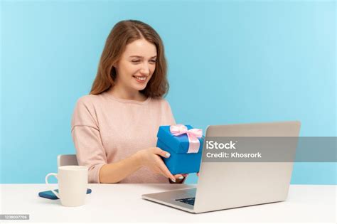 직장에 혼자 앉아 노트북 화면에 선물 상자를 보여주는 아름다운 여자 화상 통화에 이야기 생일을 축하 놀라움에 대한 스톡 사진 및 기타 이미지 Istock