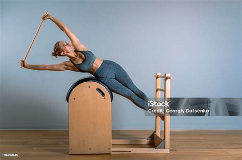 필라테스 운동을하고 아름다운 여자 배럴에 훈련 피트니스 개념 특수 피트니스 장비 건강한 라이프 스타일 플라스틱 복사 공간 광고를위한 스포츠 배너 필라테스에 대한 스톡 사진