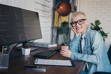 Young Female Programmer At Work Station Coding On Multiple Monitors In A Modern Home Office