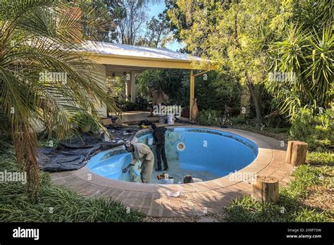 Workman Using Rollers And A Paintbrush To Apply Fibreglass Gel Coat