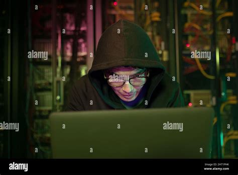 Asian Male Hacker Using A Laptop In Computer Server Room Stock Photo Alamy