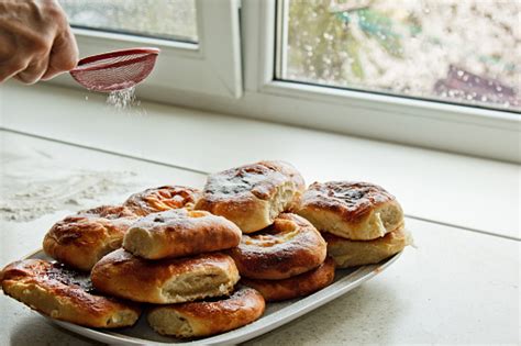 갓 구운 치즈 케이크로 가득 찬 접시에 빵 식탁에 가루 설탕을 뿌린 여성 손 요리 베이킹 베이킹 롤 준비 단계 아침 식사 근접 촬영 복사 공간 Performing Arts