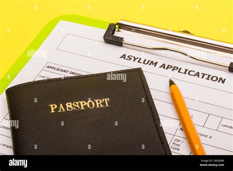 Asylum Concept Showing An Application Form For Asylum On A Yellow Background With A Pen And A