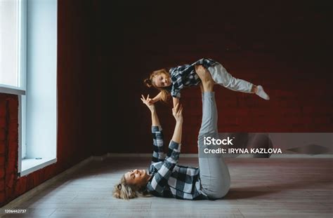 젊은 스포티 한 어머니와 어린 소녀는 로프트 스튜디오에서 함께 체조 운동을 스트레칭하고 2명에 대한 스톡 사진 및 기타 이미지