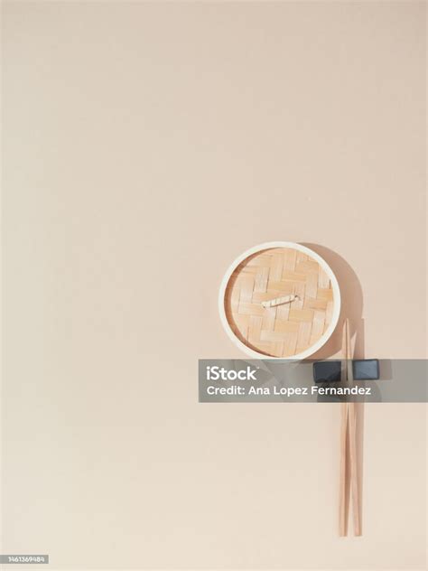 복사 공간이 있는 일반 모래 색 배경에 전통적인 중국 대나무 증기선과 젓가락의 미니멀리스트 평면도 동양 배달 음식 개념입니다