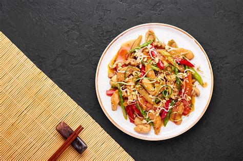 검은 슬레이트 배경에 흰색 접시에 치킨 찹 수이 Chop Suey는 다양한 볶음 야채 닭고기 소스를 곁들인 미국 식 중국 요리입니다 공간을 복사합니다 맨 위 보기 미국