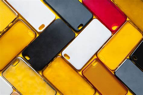 휴대 전화에 대한 여러 가지 빛깔의 플라스틱 뒷면 커버의 더미 스마트 폰 보호자 케이스 액세서리 배경의 선택 노란색 배경에