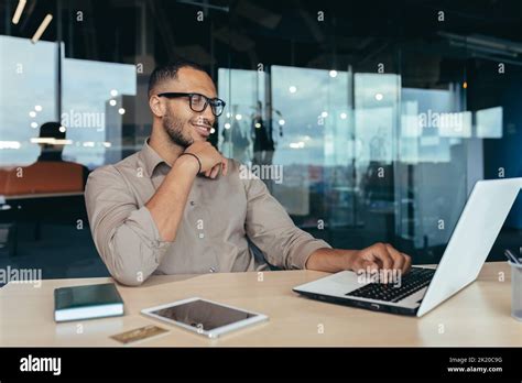 happy and successful indian man working in modern office building