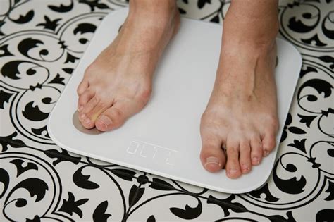 Premium Photo Woman Checking Her Weight On Weighing Scales In Bathroom