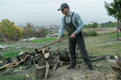 나무 더미 근처에서 막대기를 들고 있는 남자 사진 Unsplash의 농장 이미지